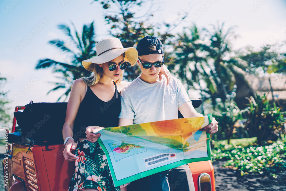 Foto de Male and female hipsters reading map with routes journey on ...