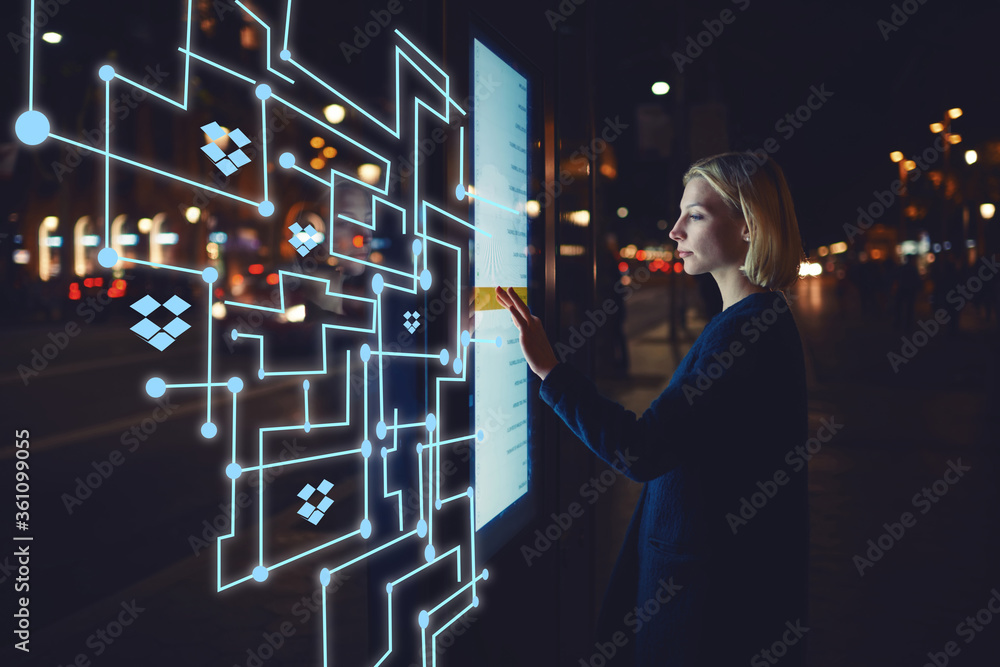 Stockfoto Young woman touching sensitive screen while selecting surface ...