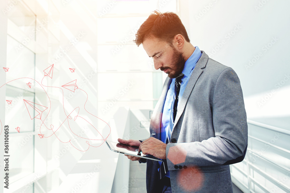 Young businessman in suit working on digital tablet in modern office ...