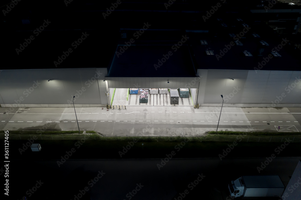 Night Aerial view of trucks unloading in logostics center. Logistics ...