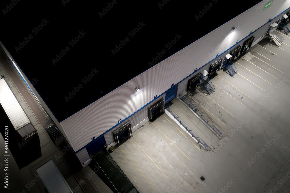 Night Aerial view of trucks unloading in logostics center. Logistics ...