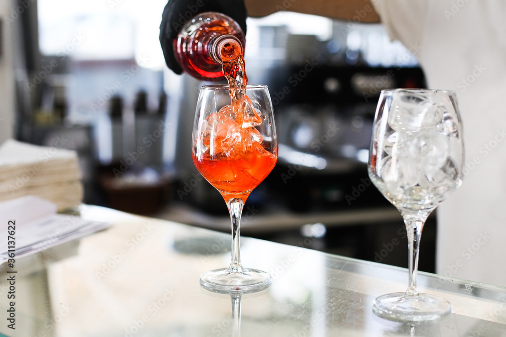 A process of making traditional Italian aperitif - Aperol Spritz in a ...