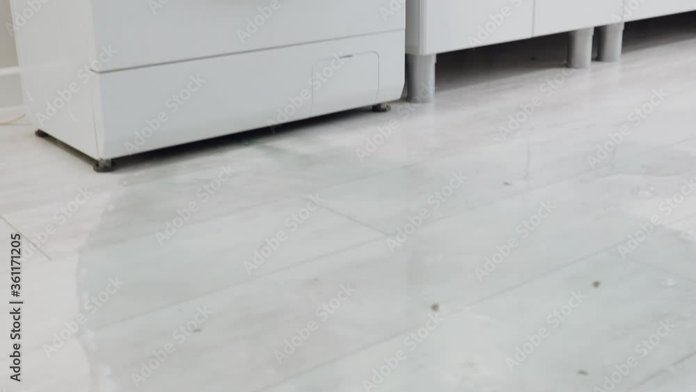 Close-up of a housewife's feet in Slippers, the washing machine broke ...