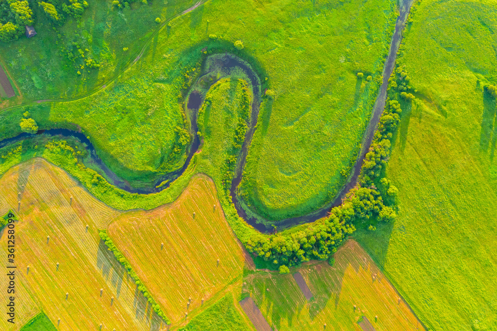 Top aerial view of the natural landscape valley of a meandering river ...