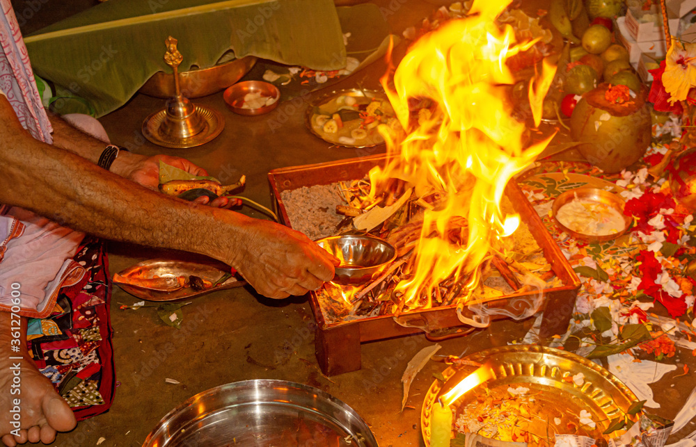 Hand of a hindu brahmin priest worshiping hindu God by performing yajna ...