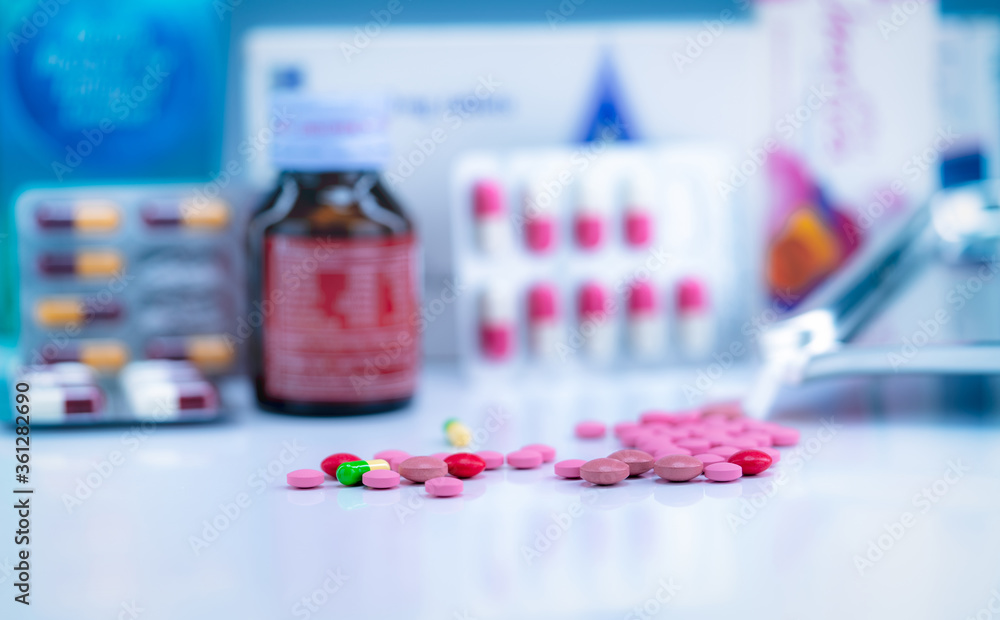 Pile of colorful tablets and capsules pills on blurred drug tray ...