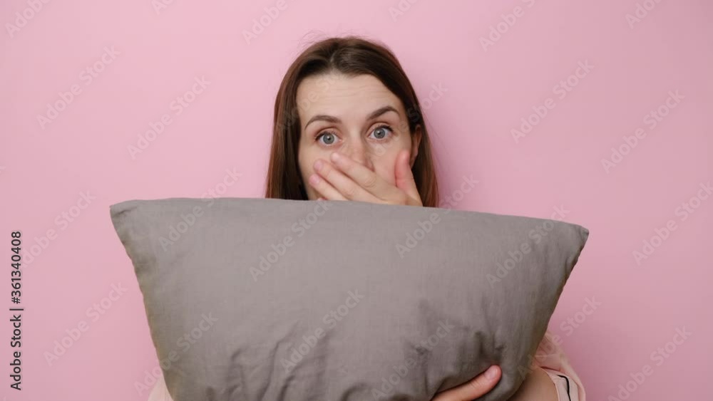 Portrait of scared young woman isolated on pink studio background look ...