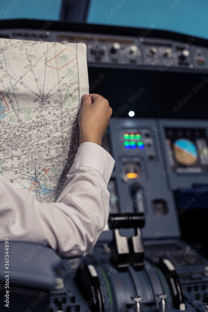 Young pilot in the aircraft in front of the dashboard. Pilot looks at ...