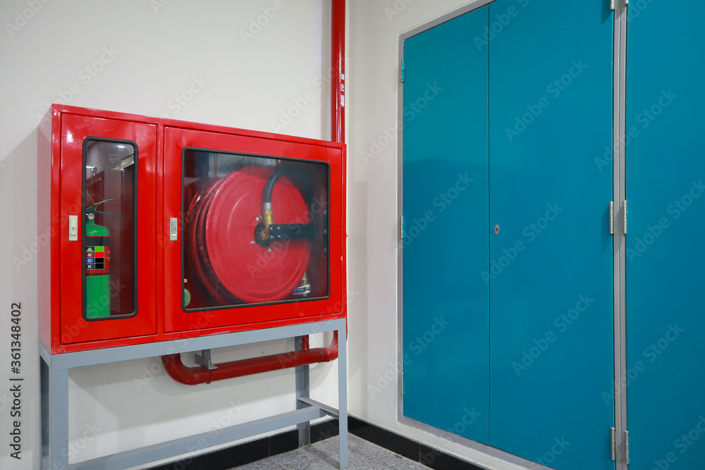 Fire hose in red box, pipe roll fire extinguisher for fire emergency in ...