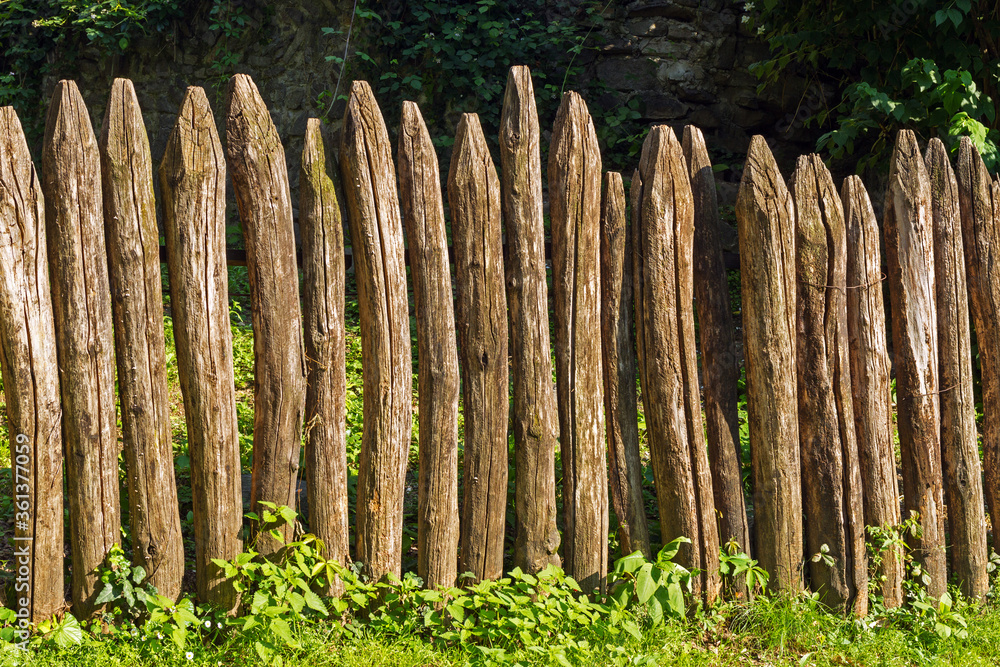 Old fence made of sharpened wooden logs. Protective structure for the ...