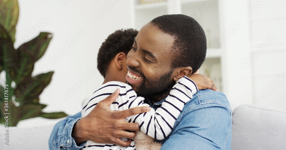 Portrait of African American dad hugging his cute little daughter ...