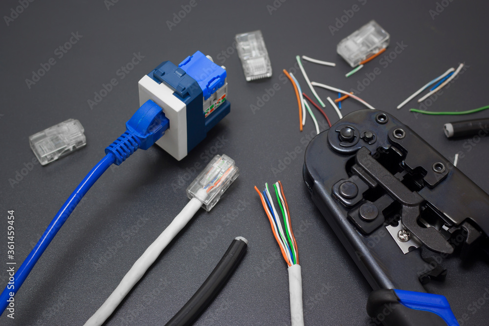 RJ45 crimping pliers with Lan cable plugged into female socket head ...