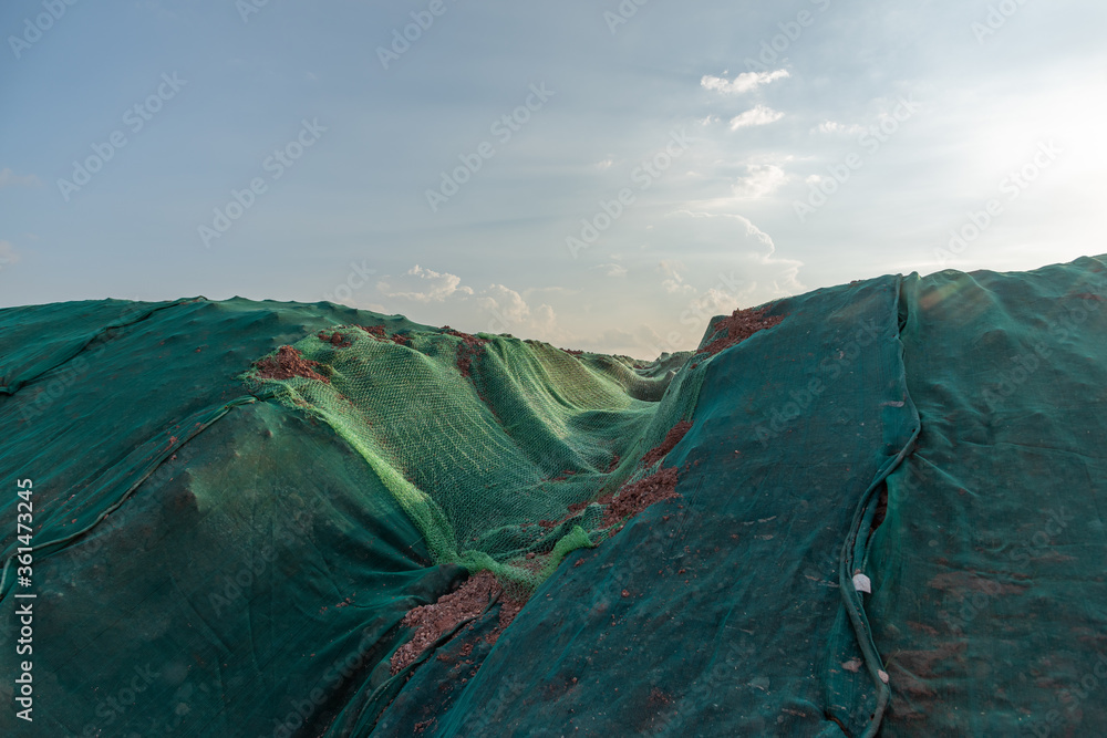 Mud piles on the construction site to prevent dust from covering the ...