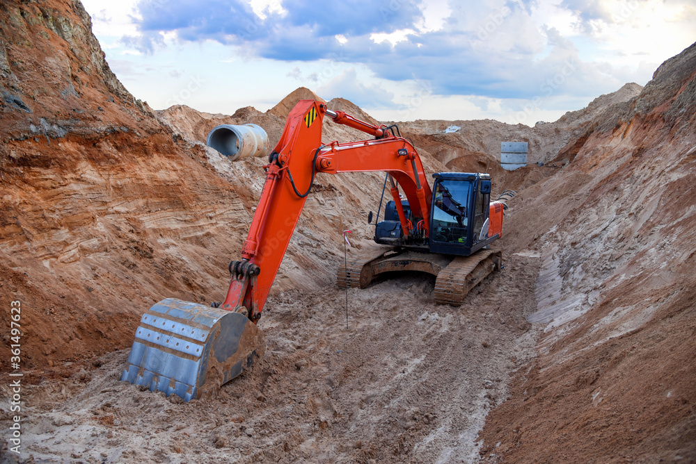 Excavator working at a construction site during laying or replacement ...
