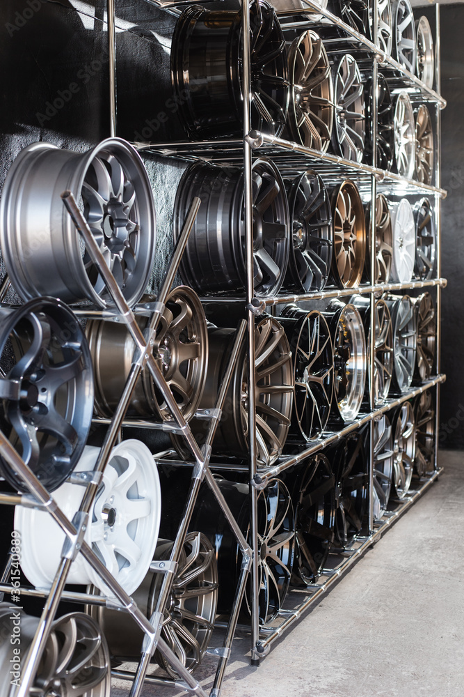 wall of alloy wheels in the store. Auto repair shop background. Auto ...