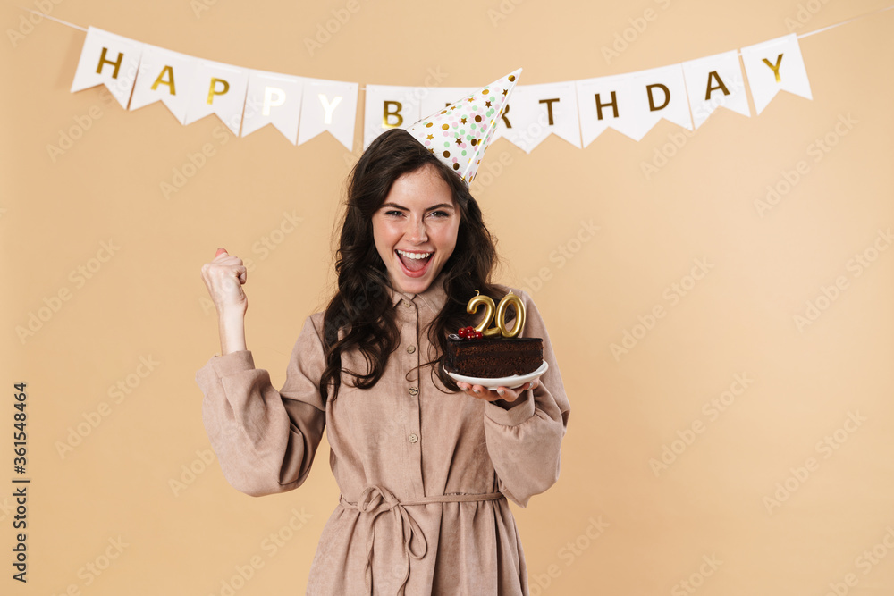 Image of woman making winner gesture while posing with birthday cake ...