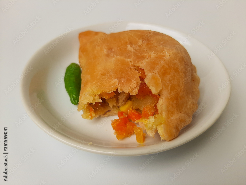 Bitten pastel. Pastel is a popular snack from Indonesia. A pastry ...