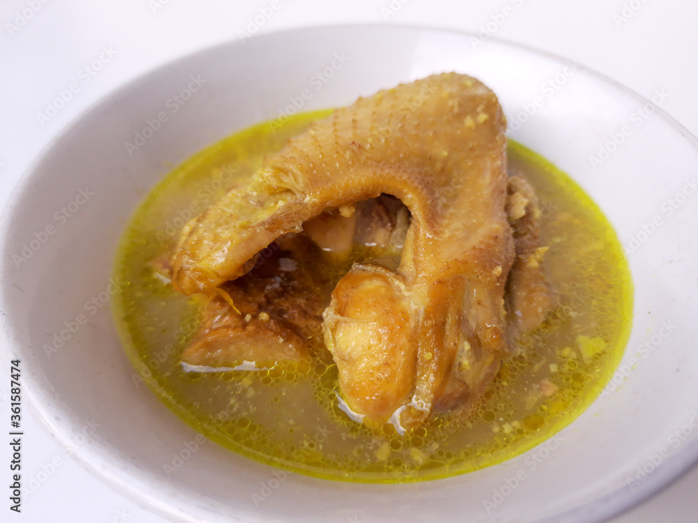 Chicken braised in coconut milk with turmeric. Indonesian food called ...