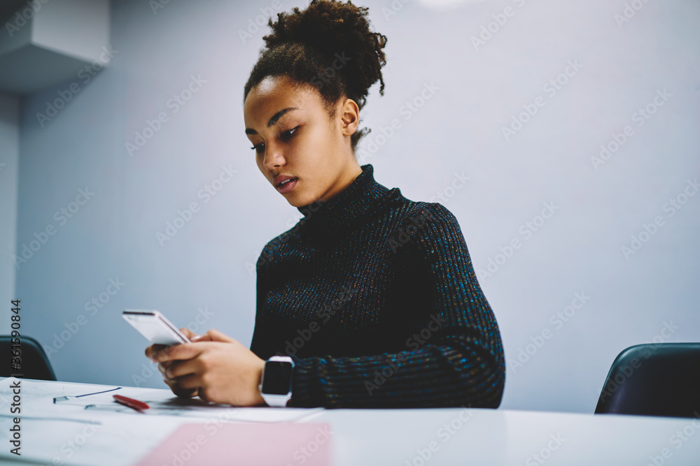 Pensive african american hipster girl checking notification on cellular ...