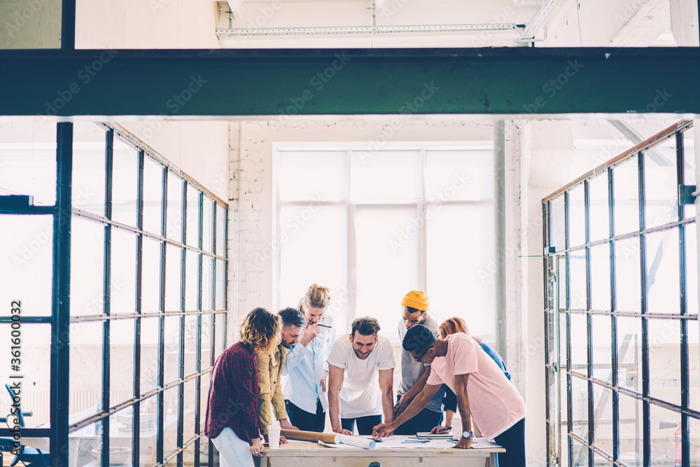 Male and female designers having conference in loft interior studio ...