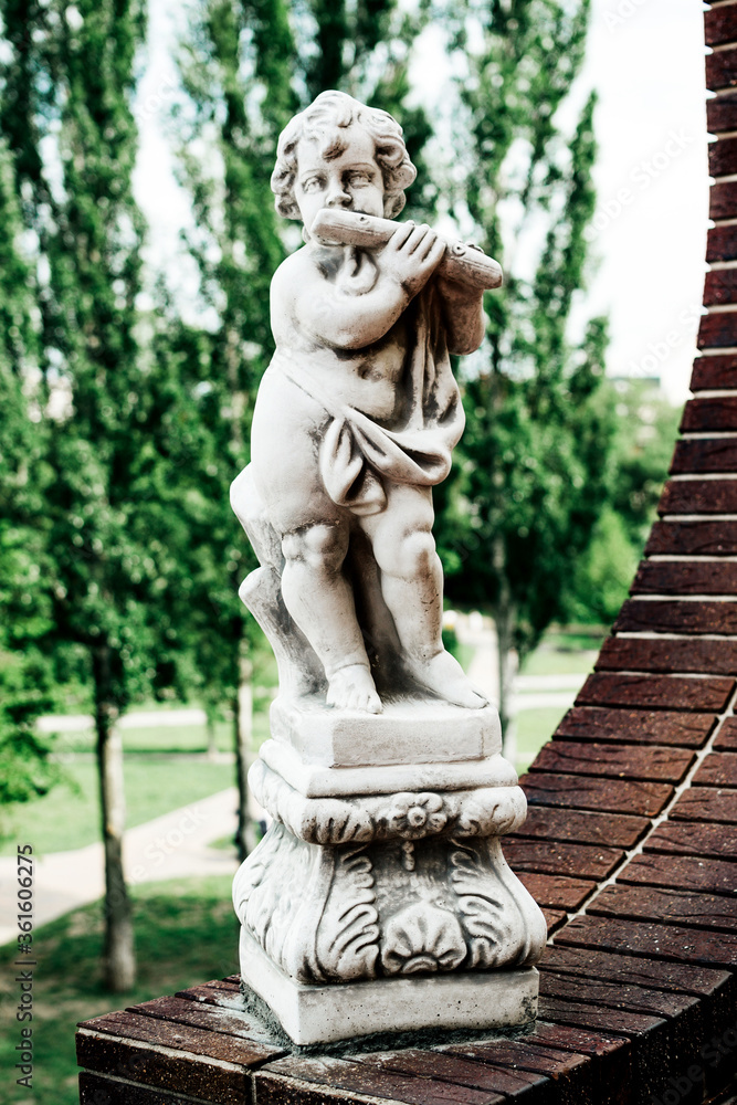 Statue of a boy on a brown stone wall Stock Photo | Adobe Stock