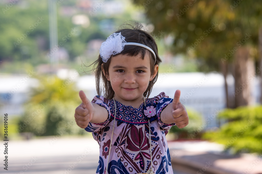 Cute smiling little child girl raising her hands up. Human emotions and ...