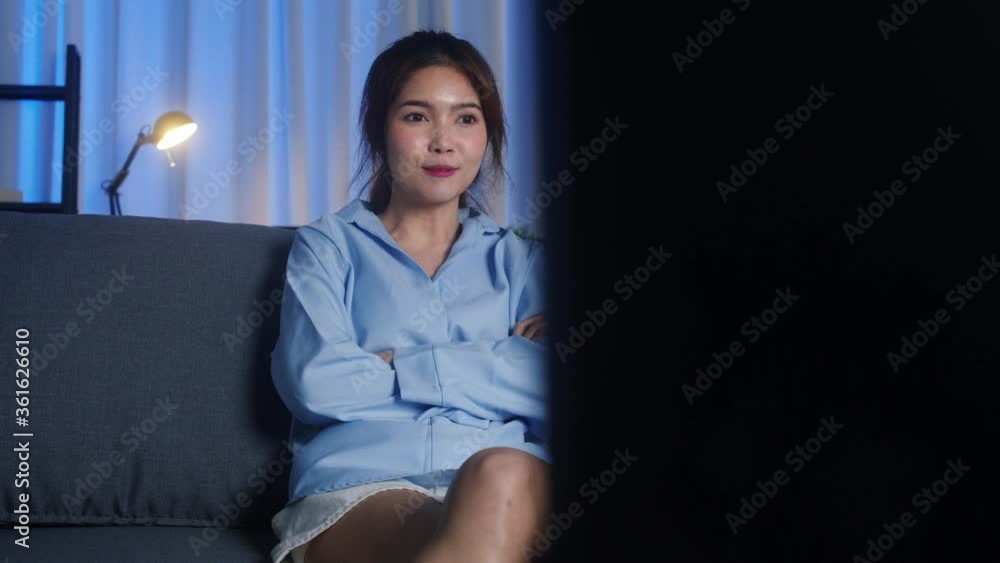 Young Asian lady watching tv feeling happy fun laugh looking television ...