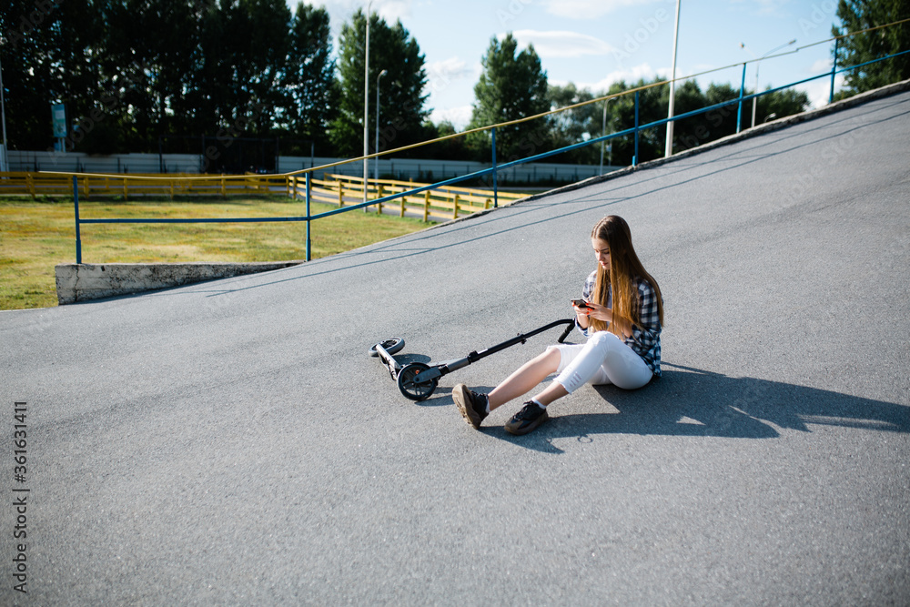 A girl checks a bruised knee that suffered from a fall while riding a ...