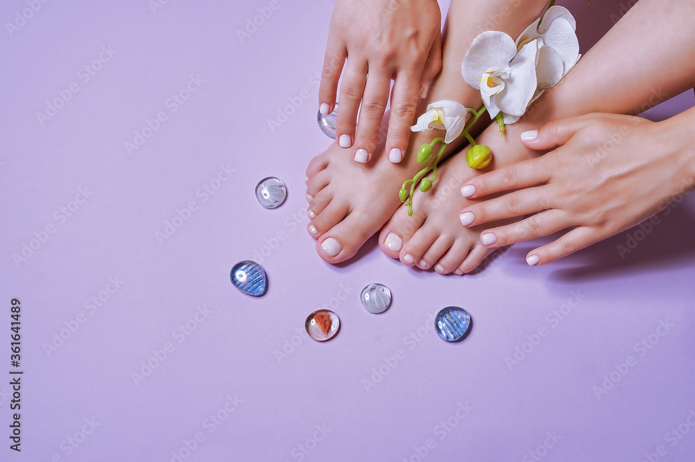 hands and feet with a beautiful manicure and pedicure and orchid on a ...