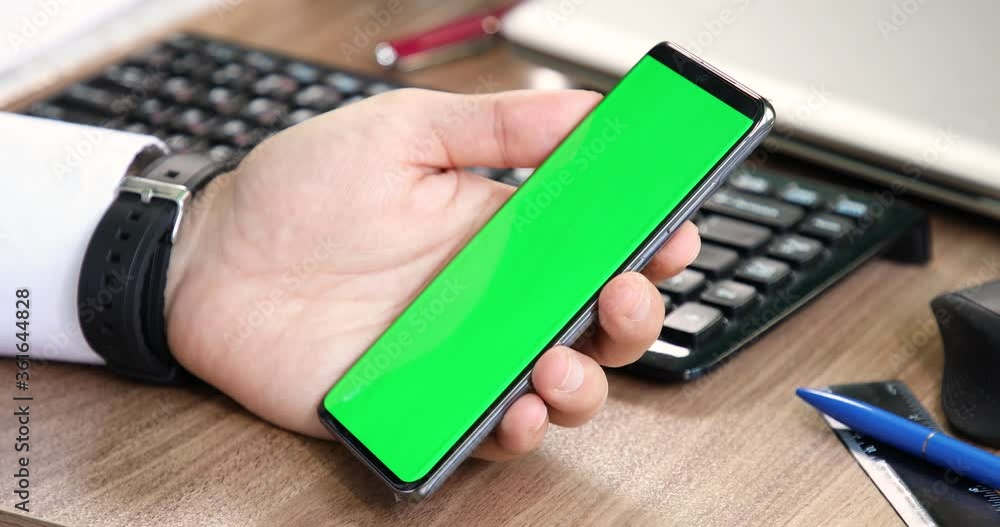 Man watching green screen smartphone display at office background Stock ...