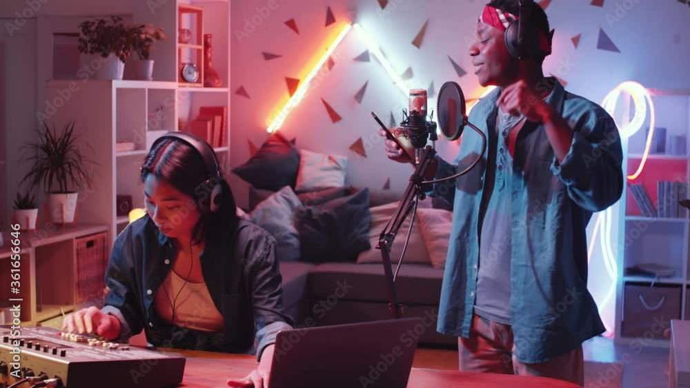 Young friends recording hip-hop at home studio: Afro-American man in ...