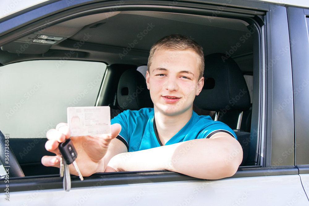 Car driver. Caucasian teen boy showing driver license, new car key and ...