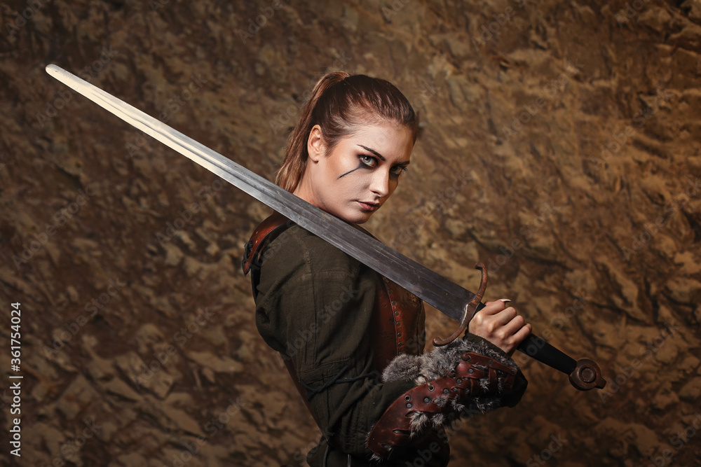 Beautiful warrior woman posing with sword Stock Photo | Adobe Stock