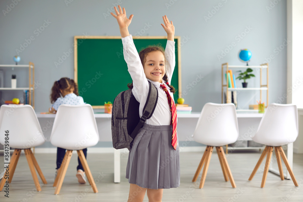 Concept back to school. Happy schoolgirl smiling raised her hands up ...