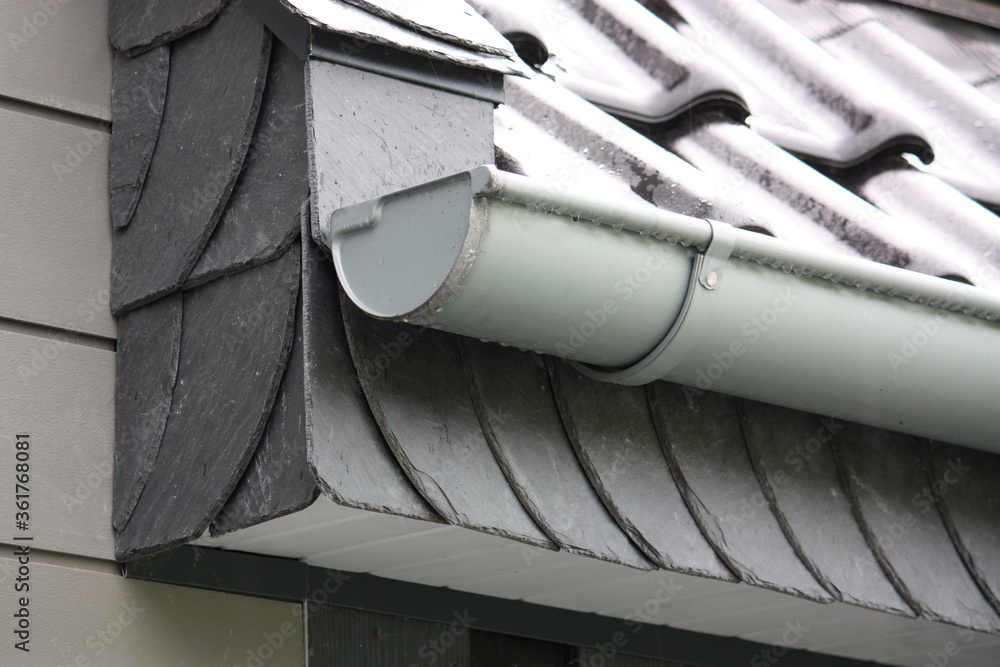 Nahaufnahme einer Dachrinne mit Schiefer an der Traufe und am Ortgang ...