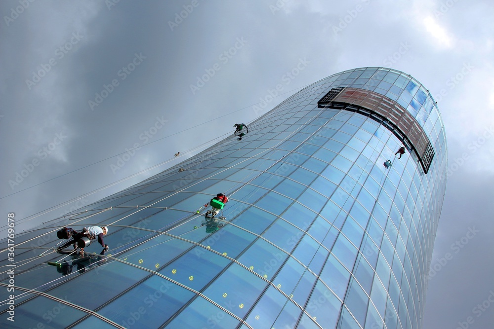 Working-climbers washing the windows on high-rise building. Stock Photo ...