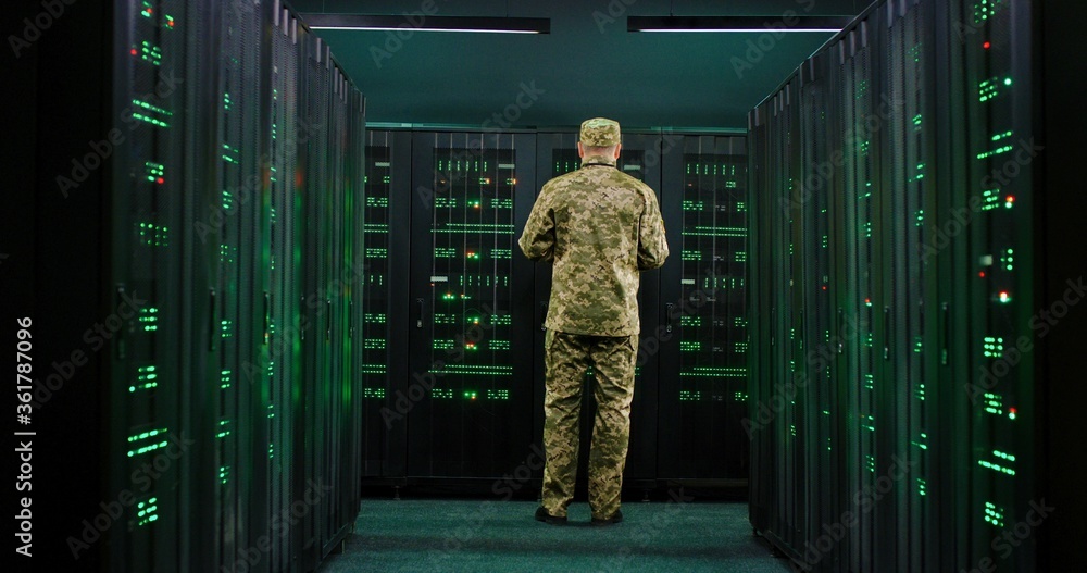 Caucasian military male officer coming in the server room with tablet ...