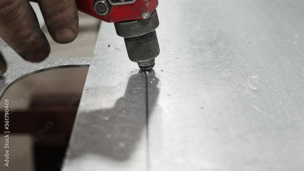 Close up video as male hands are using rivet gun. Sheet of the ...
