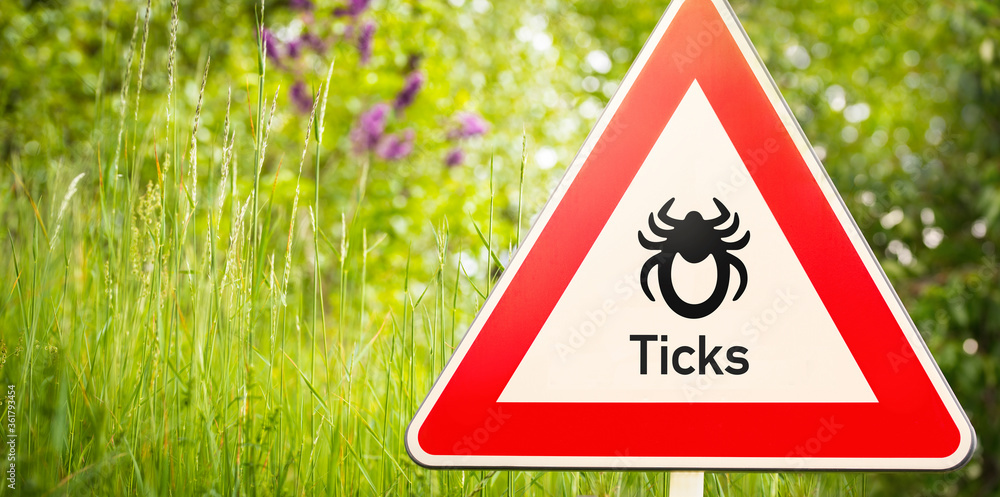 Attention sign with symbol of a tick in front of a nature background ...