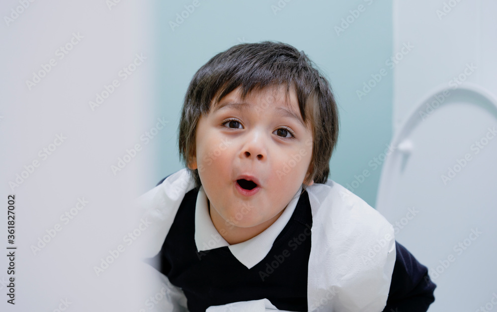School boy playing with tiolet rolls while learning how to clean him ...