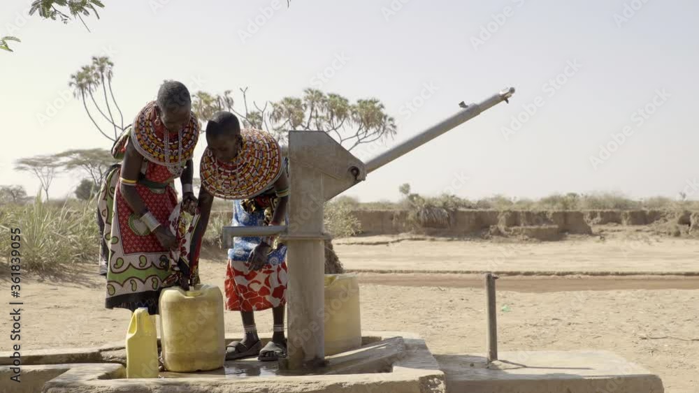 Two women collecting clean water from local borehole. The two women ...
