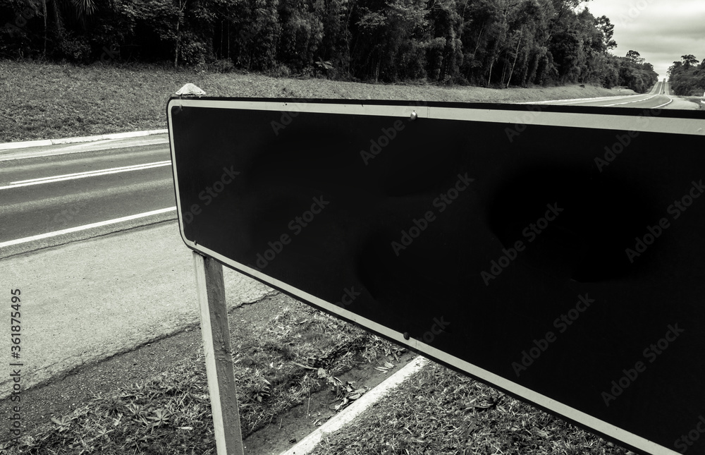 Black and white mockup of traffic sign on the shoulder of a highway ...
