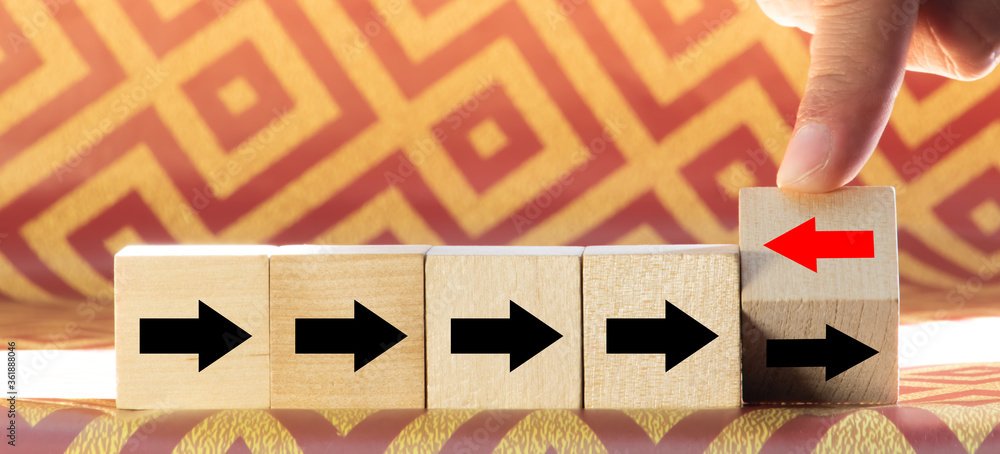 Hand flip over wooden cube block with red arrow facing the opposite ...