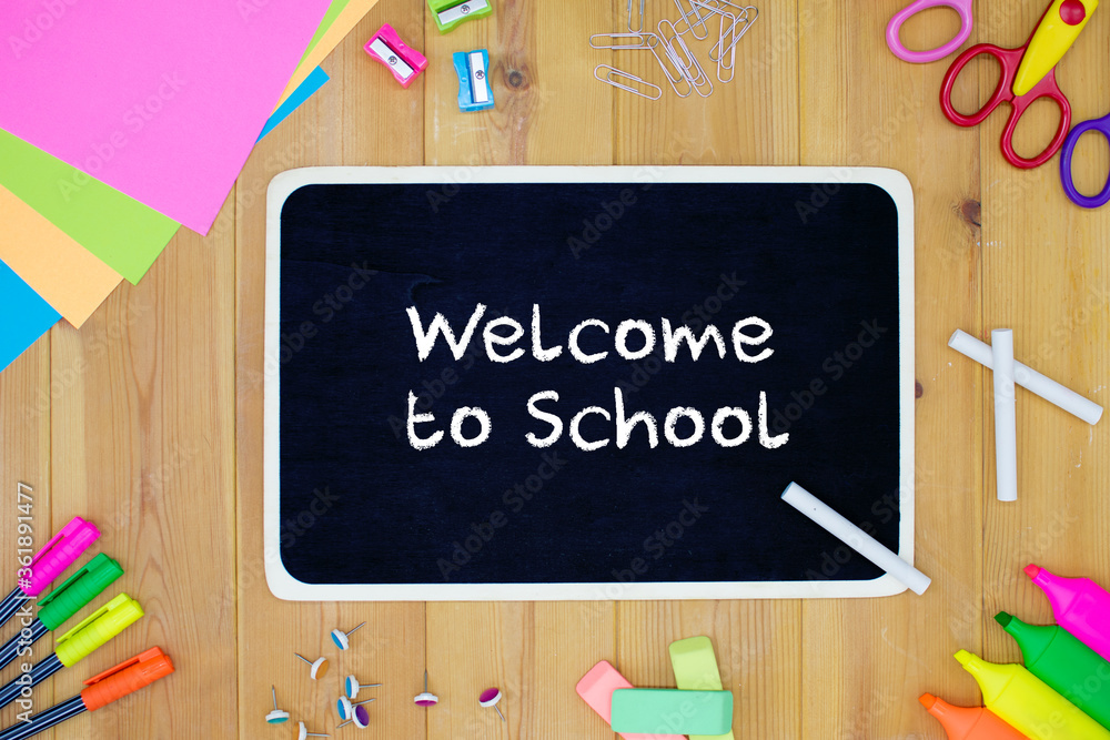 School supplies and \\\"Welcome to school\\\" written on a blackboard ...