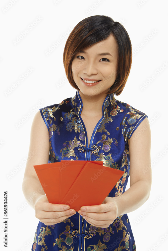 Woman in traditional clothing giving out red packets Stock Photo ...