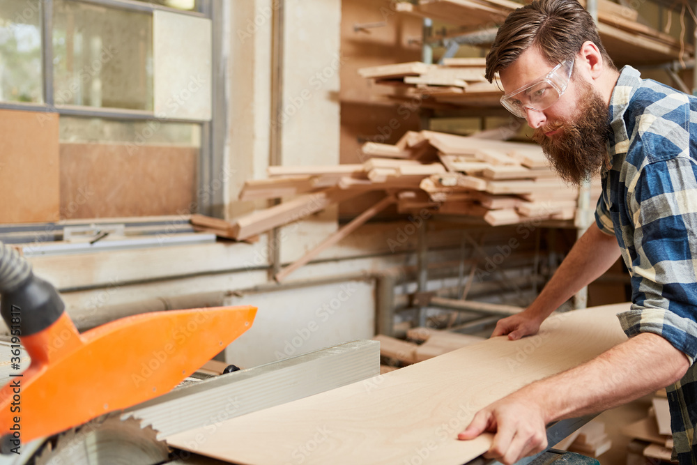 Man as a carpenter cuts a wood board Stock Photo | Adobe Stock