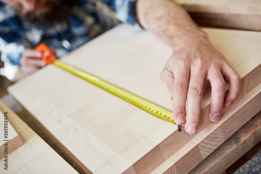 Furniture maker with measuring tape when measuring wood Stock Photo ...