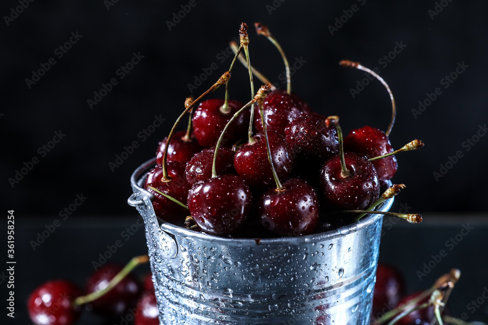 Red sweet cherries close up in a metal bucket on black background ...
