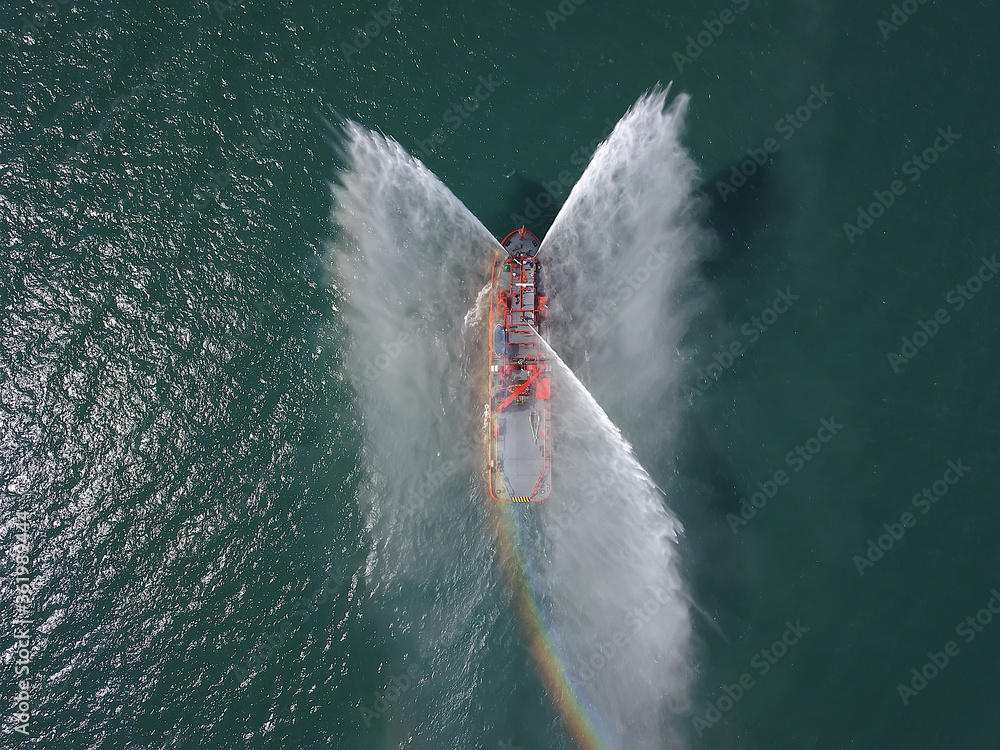 A floating modern ship sprays jets of water, demonstrates fire fighting ...
