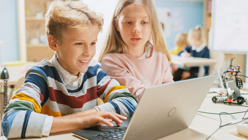 Brilliant Schoolgirl and Schoolboy Talk and Use Laptop to Program ...